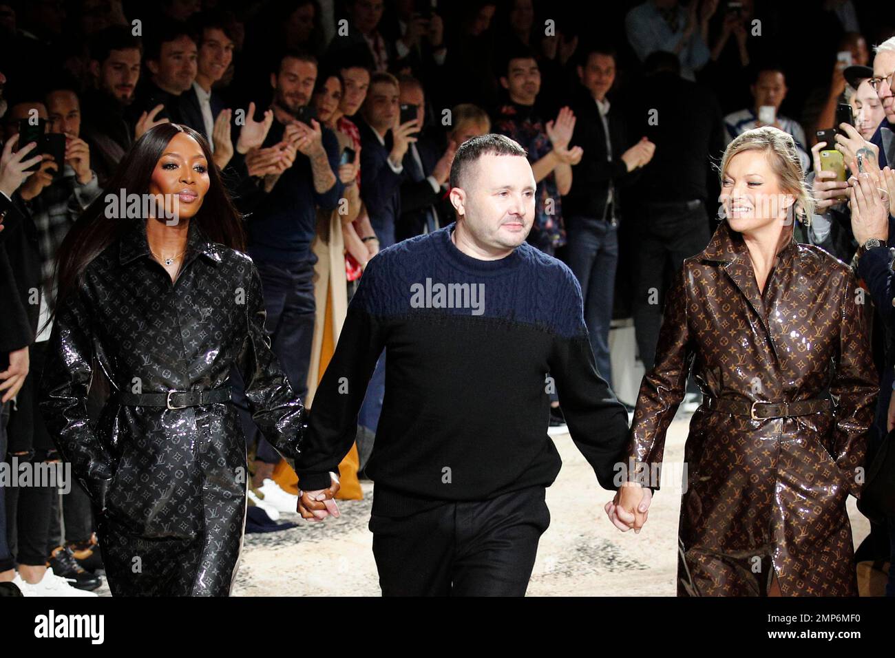 Designer Kim Jones, centre, accepts applause as he walks with models ...