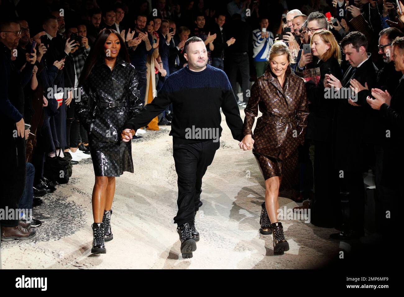 Designer Kim Jones, centre, accepts applause as he walks with models ...