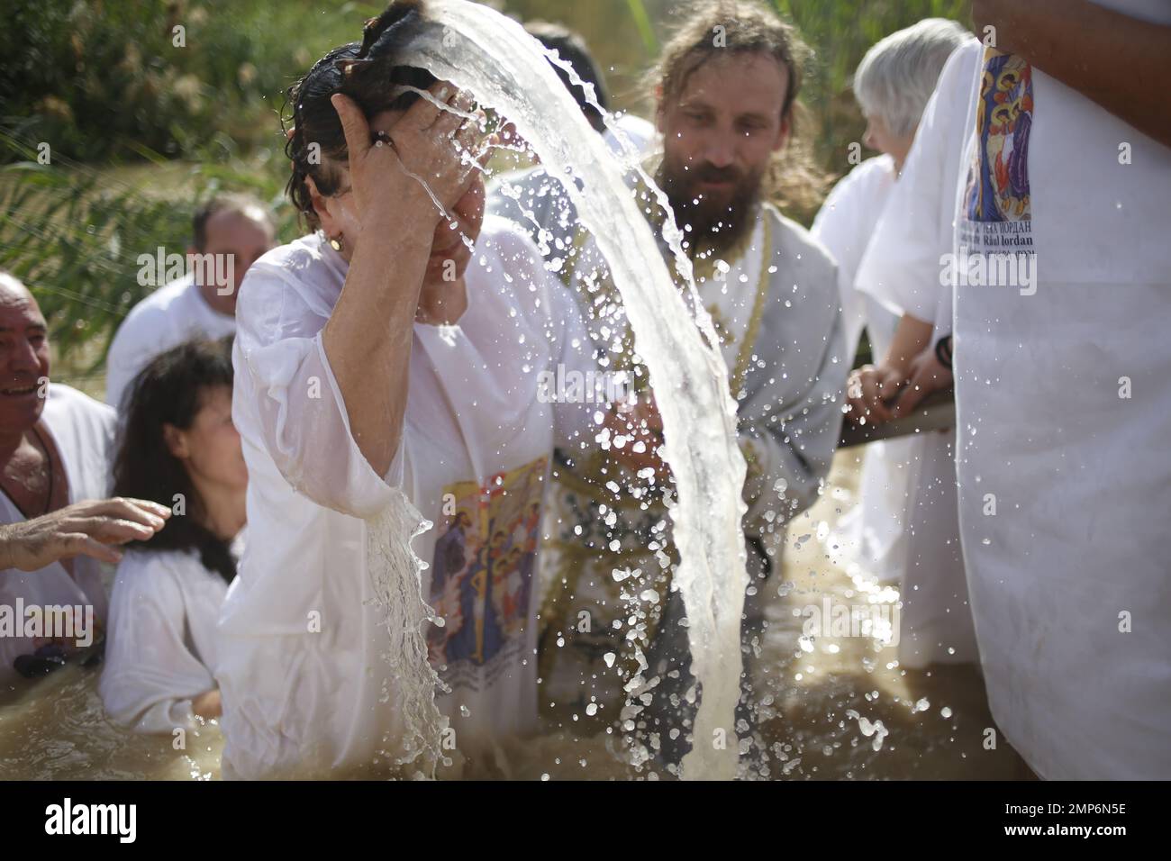 A Christian Orthodox priest re-enacts the baptism of Jesus, during the ...
