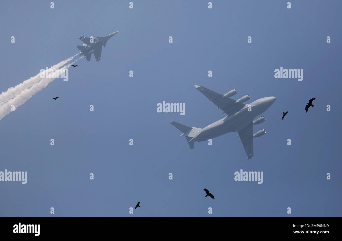 Birds fly past as Indian Air Force Sukhoi fighter jet, left, and Indian ...