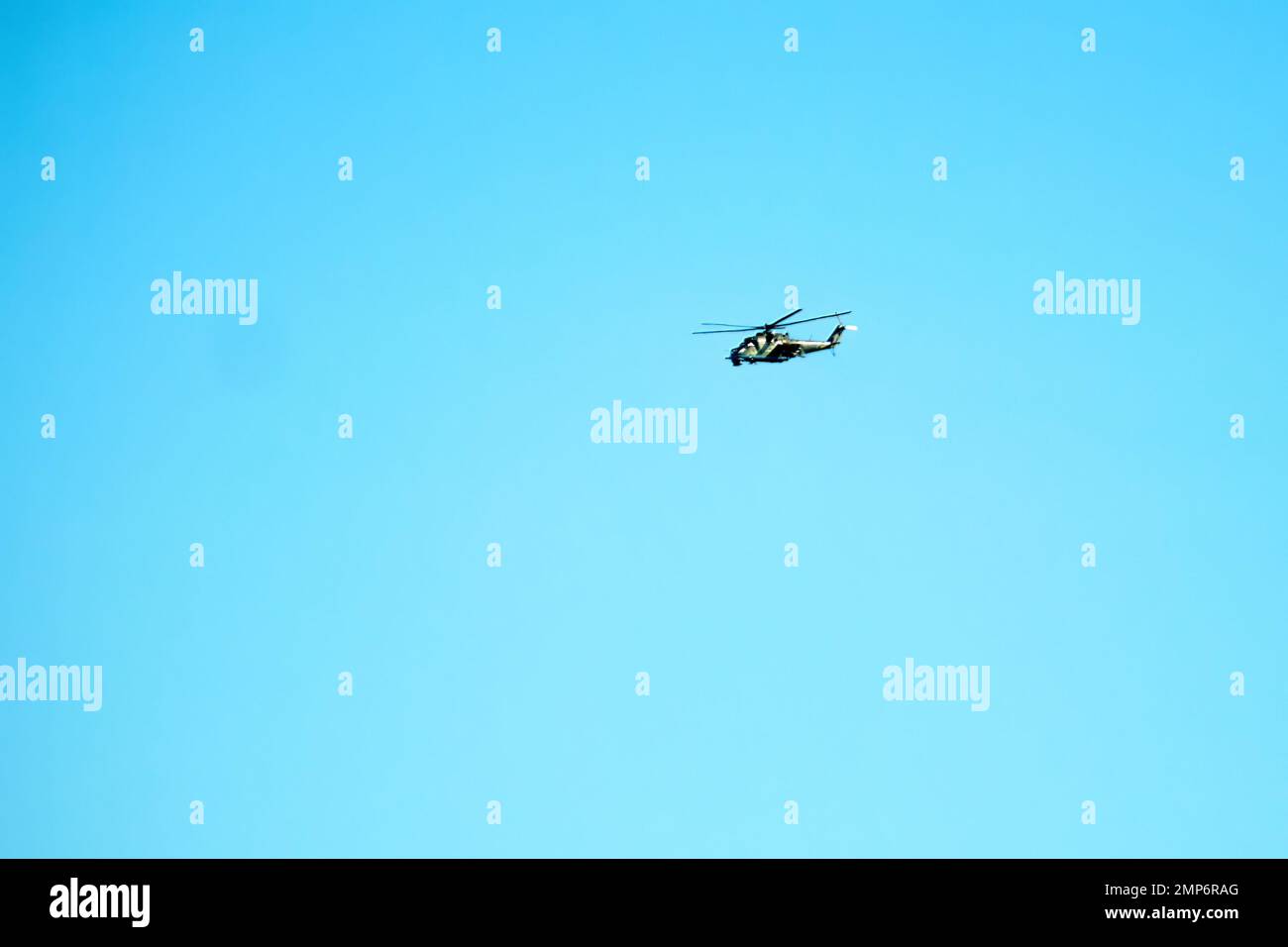 flight of one combat helicopter against the background of the blue sky ...