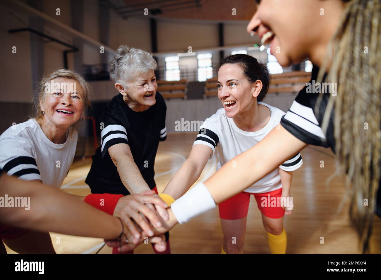 Group of multigenerational women in gym stacking hands together, sport ...