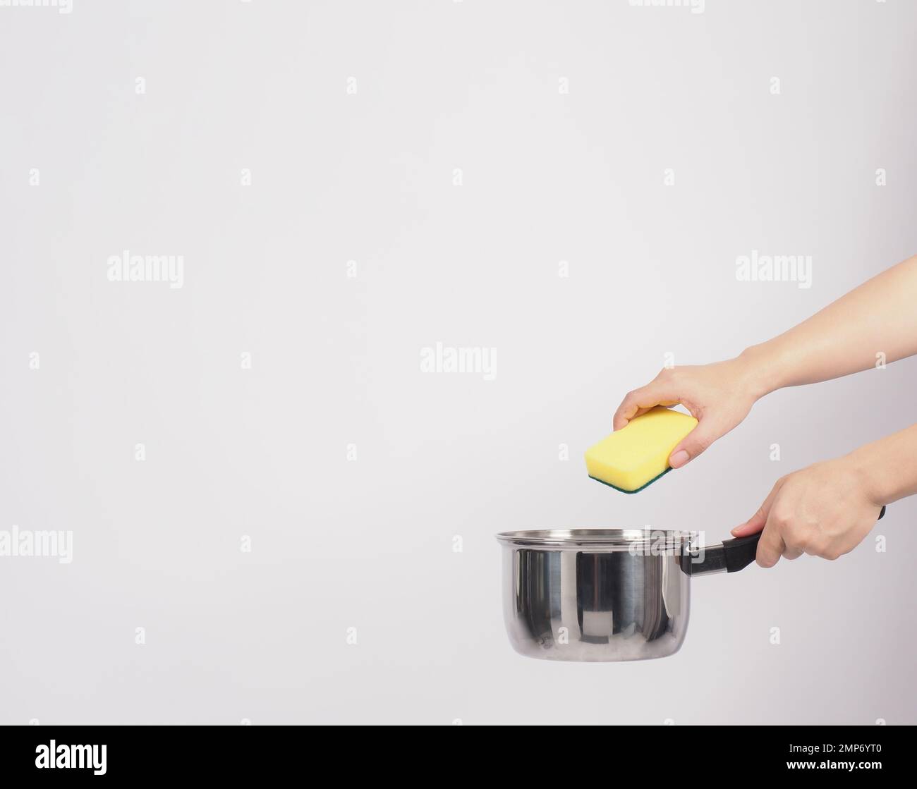 Pot cleaning Man hand on white background cleaning the non stick pot ...