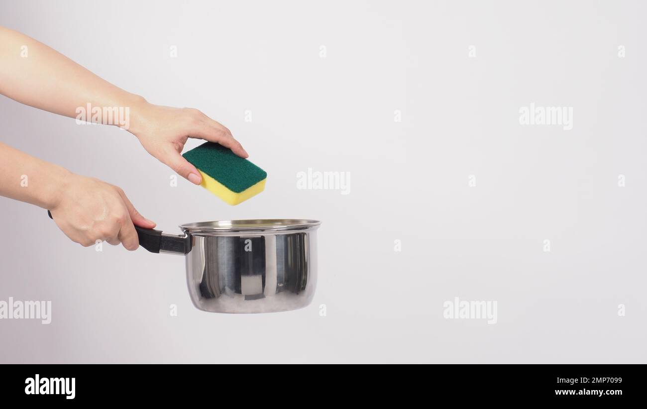 Pot cleaning Man hand on white background cleaning the non stick pot ...