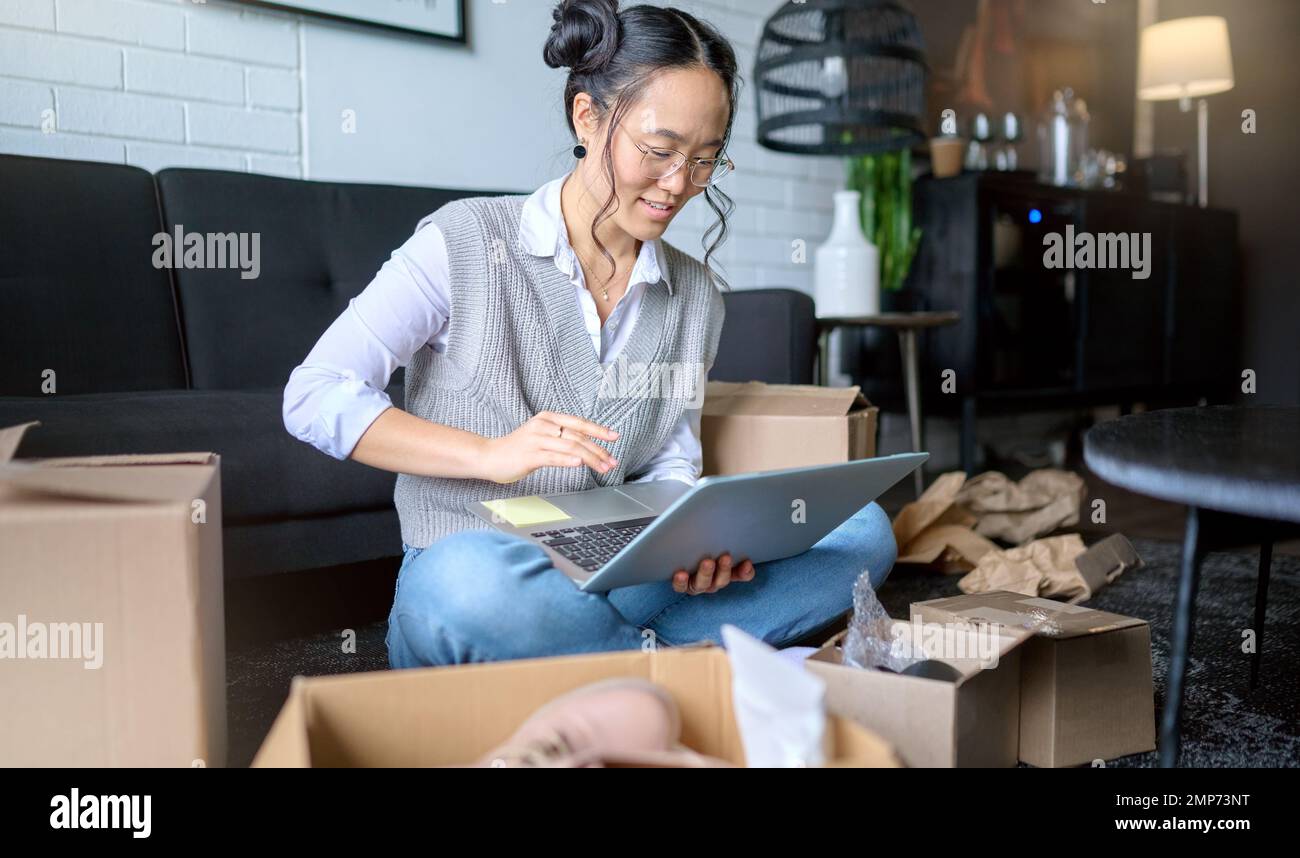 Real estate, laptop and Asian woman moving into new home while planning ...