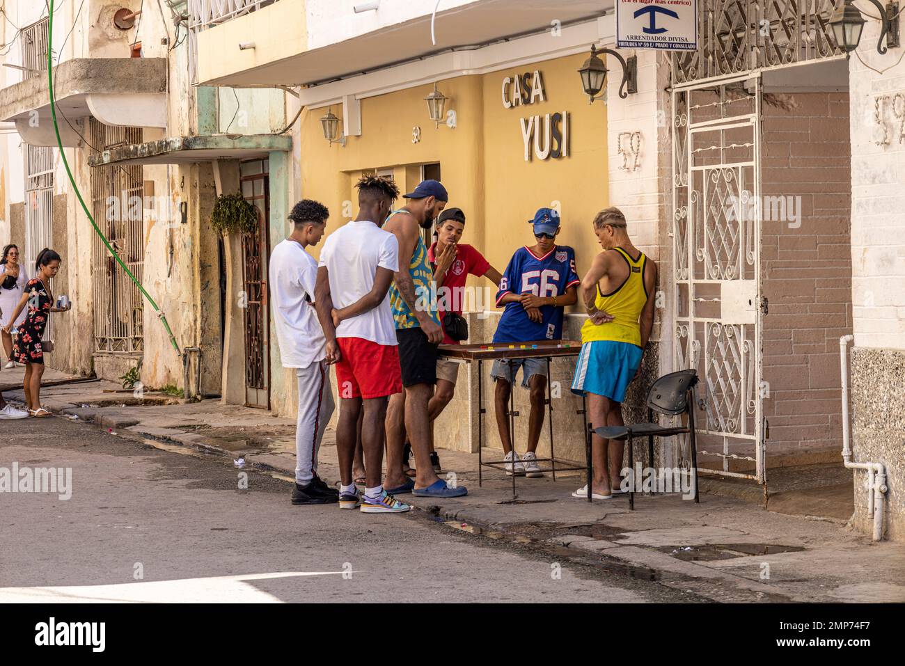 Young men playing board game in street outside Casa Yusi, Old Havana ...