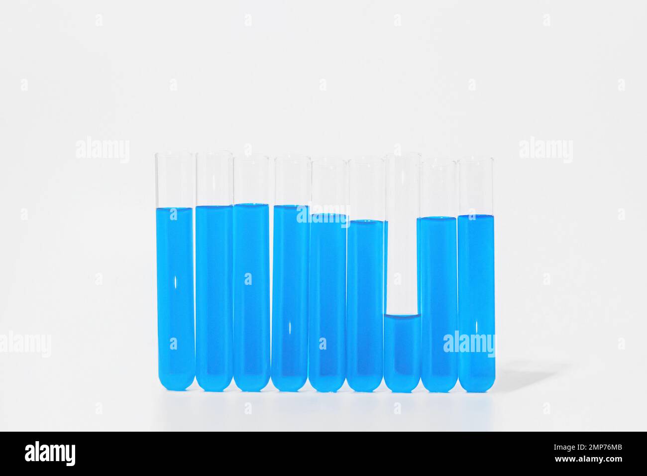 Transparent glass test tubes on a white background, blue liquid ...