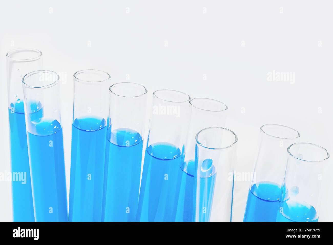 Transparent glass test tubes on a white background, blue liquid ...