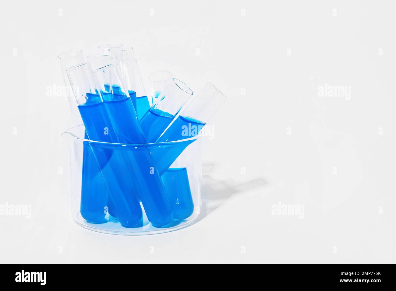 Transparent glass test tubes on a white background, blue liquid ...