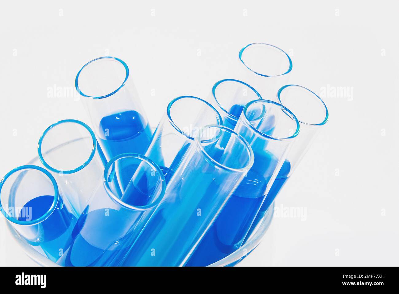 Transparent glass test tubes on a white background, blue liquid ...