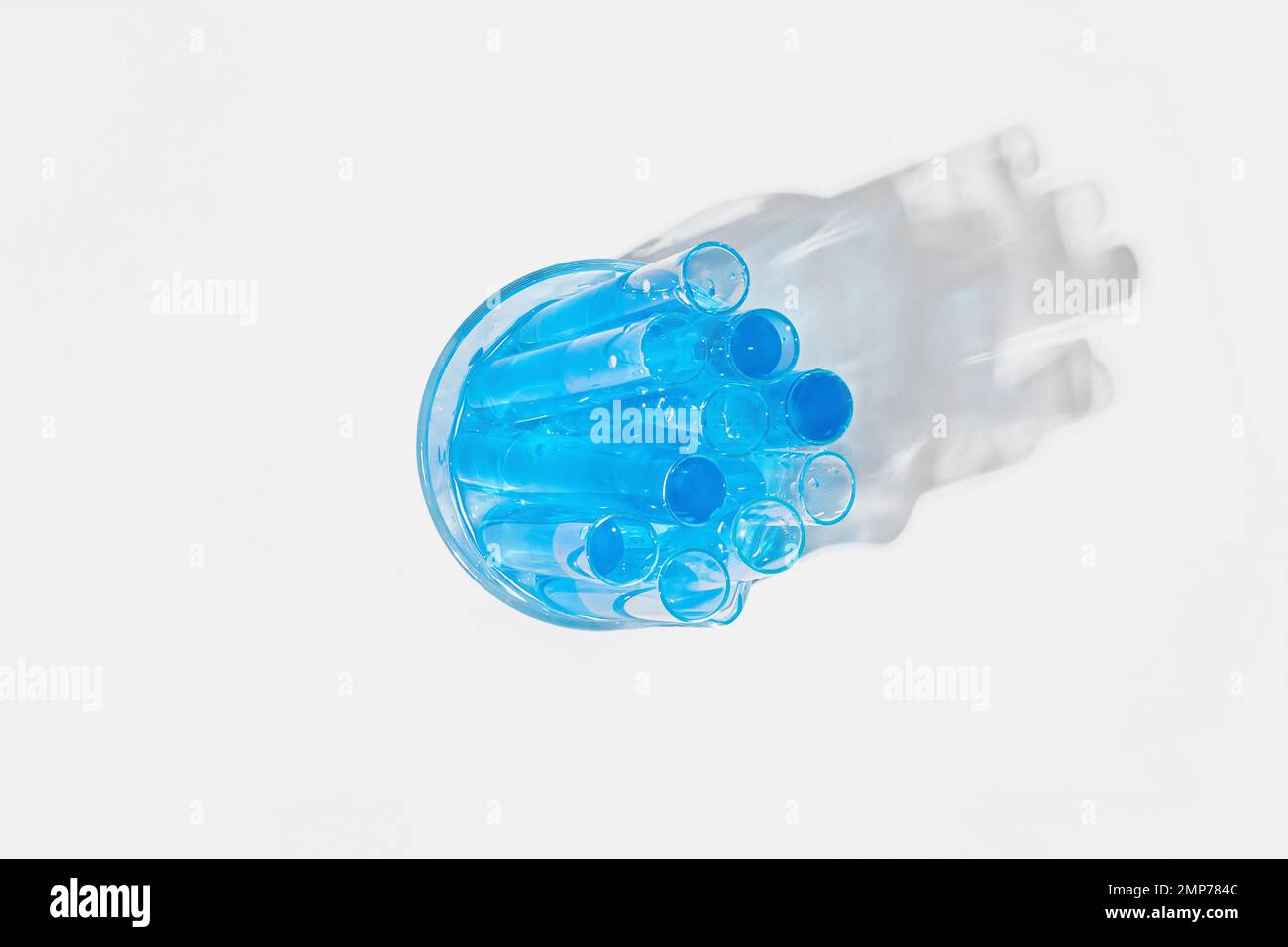 Transparent glass test tubes on a white background, blue liquid ...