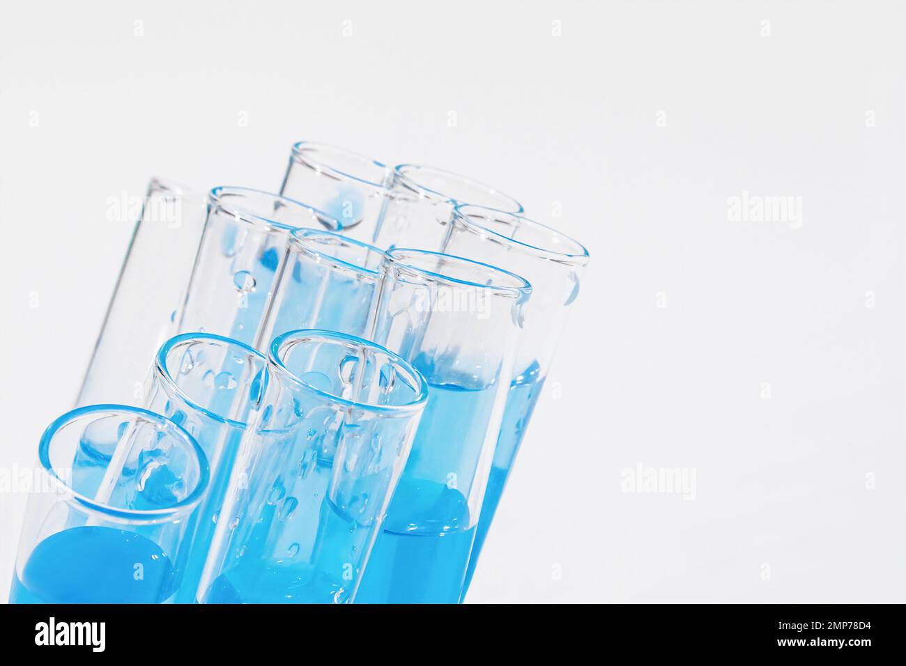 Transparent glass test tubes on a white background, blue liquid ...