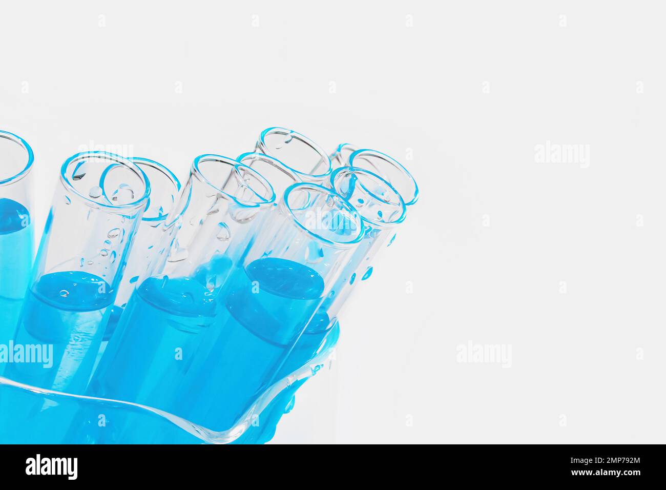 Transparent glass test tubes on a white background, blue liquid ...