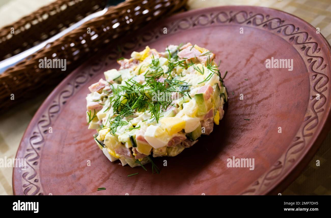 traditional Russian salad with peas and mayonnaise, served in a ...