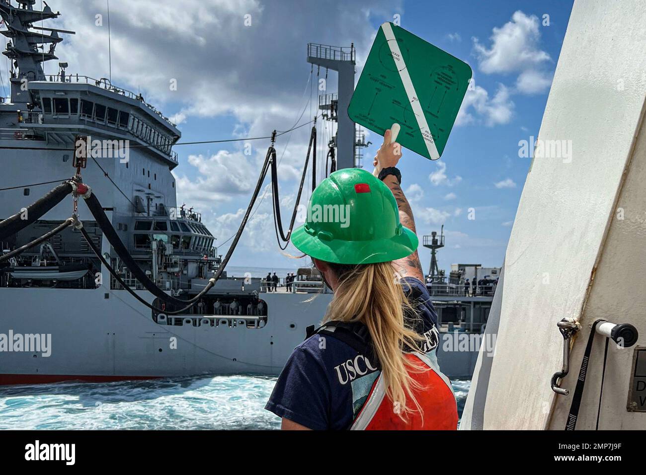 Seaman Brooklyn Baker holds up a signaling board from U.S. Coast Guard ...