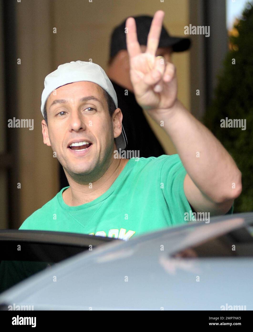 Adam Sandler flashes a peace sign as he leaves his luxury hotel with ...