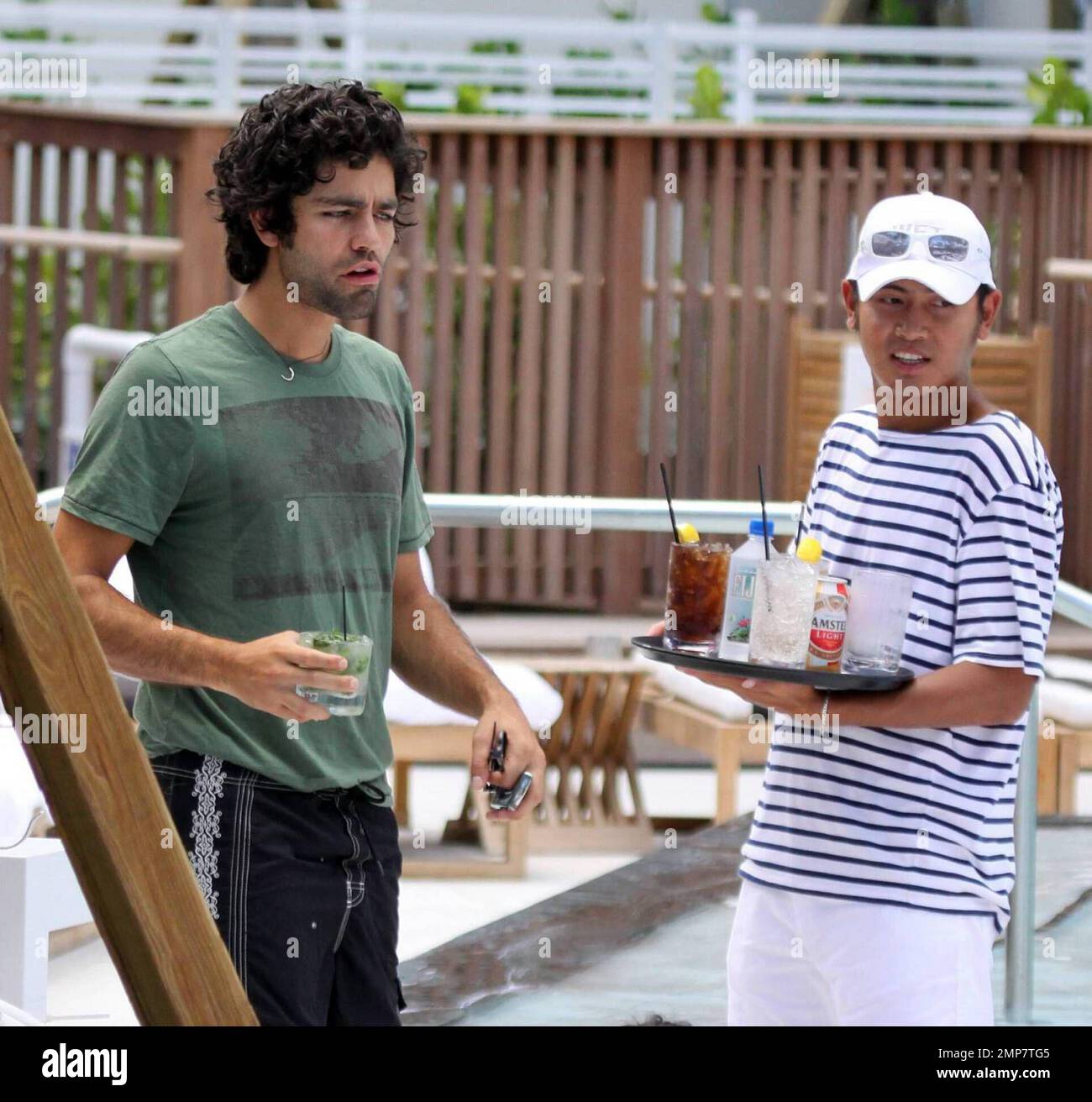 Adrian Grenier and his "entourage" lounge poolside. The actor is in ...
