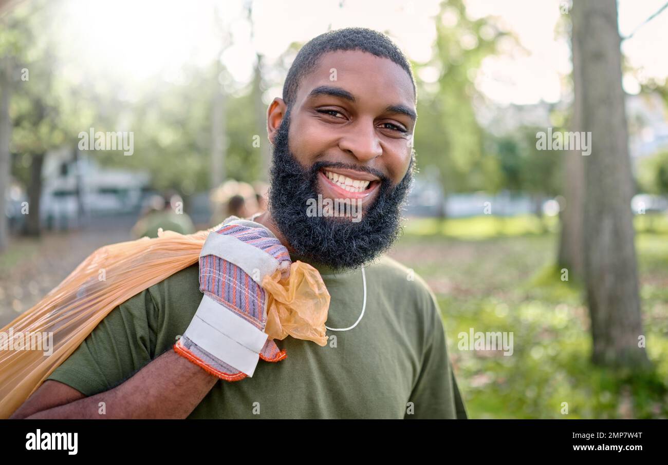 Plastic bag, park and black man cleaning for earth day, eco friendly or ...
