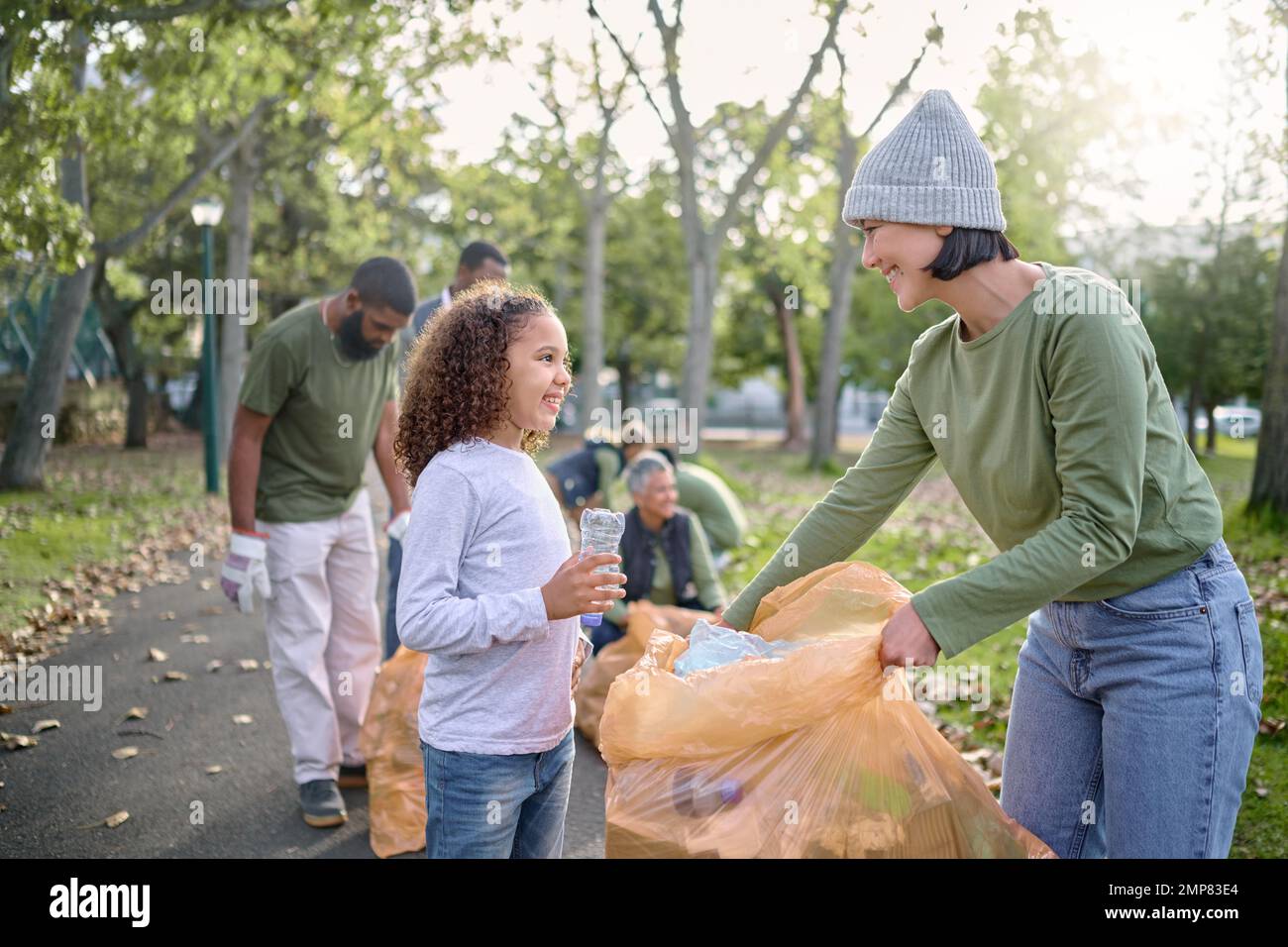 Trash volunteer, happy woman and child cleaning garbage, pollution or ...