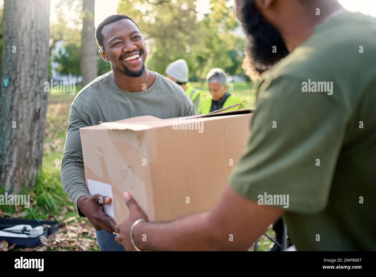 Black man, volunteering and giving box in park of donation, community ...