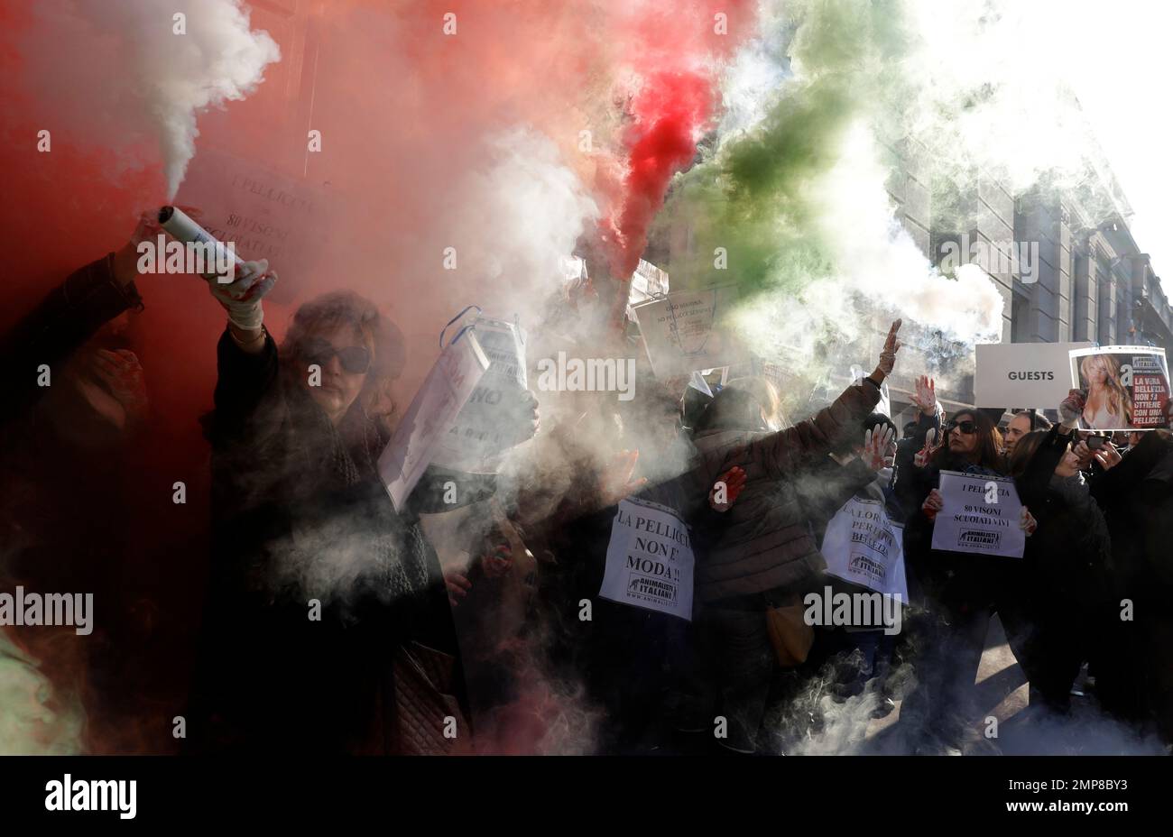 Anti fur protesters light flares and hold banners reading "1 fur = 80 ...