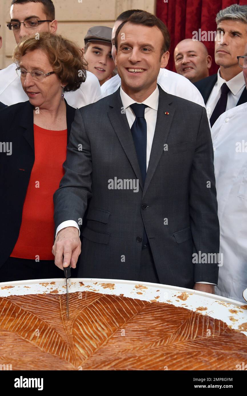 French President Emmanuel Macron cuts a slice of a traditional epiphany ...