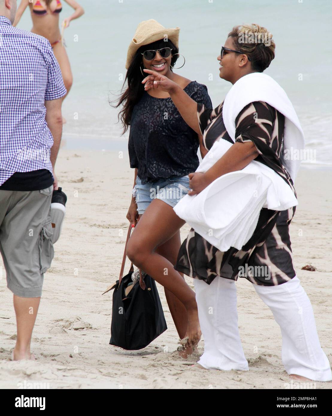 Wearing denim short shorts, UK singer Alexandra Burke chats to friends ...