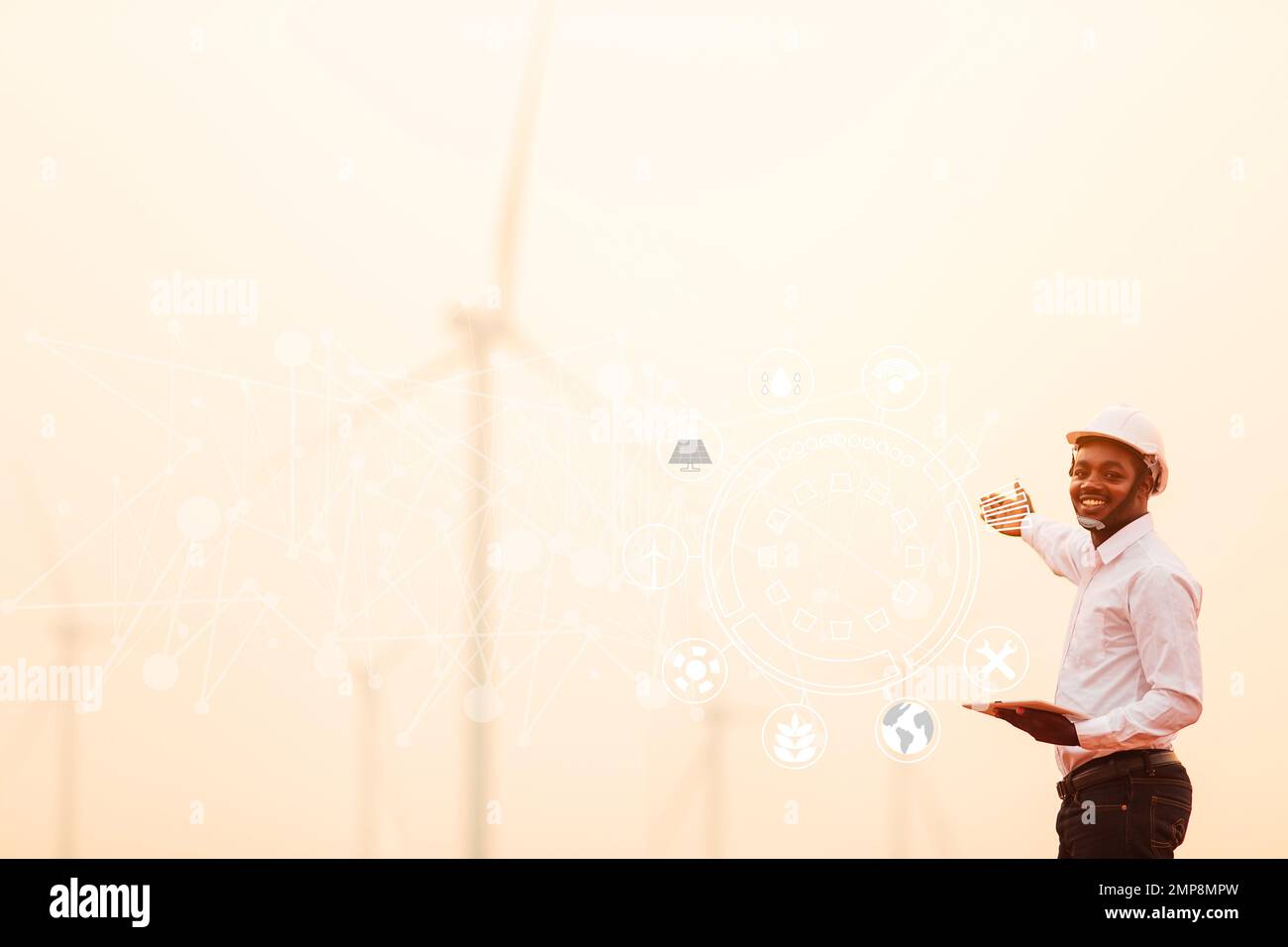 African engineer man stands holding tablet front the wind turbines ...