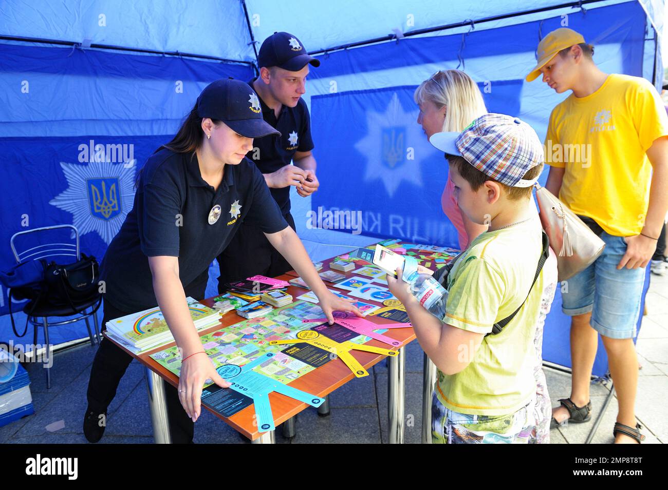 Police officers standing under a tent and giving brochures out to ...