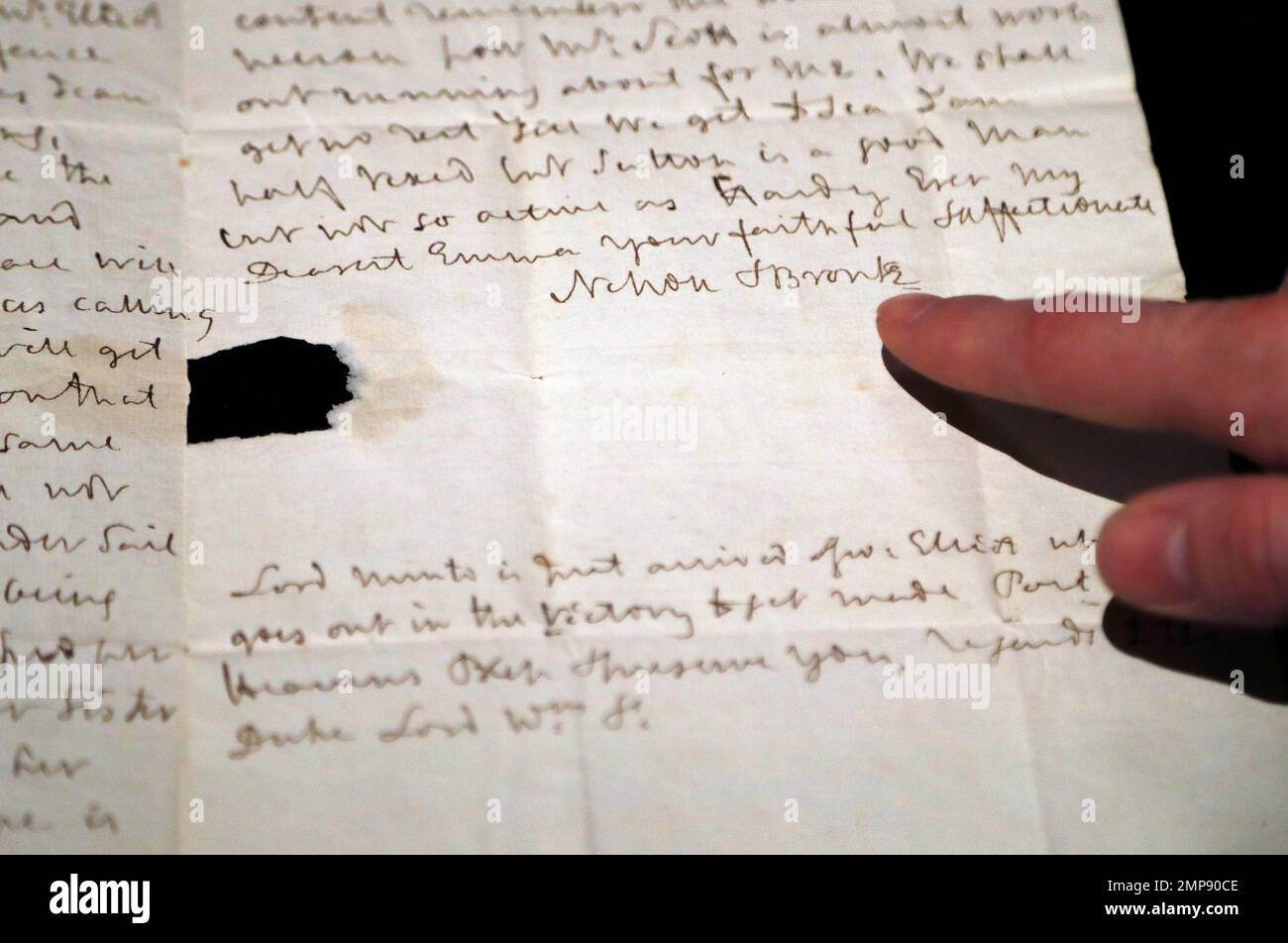 A Sotheby's employee points to a signature of Lord Nelson on a letter ...