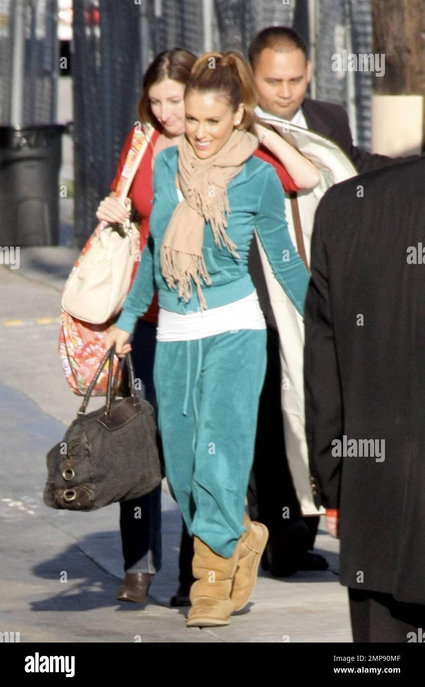 Wearing a blue-green track suit and a tan scarf along with a pair of ...