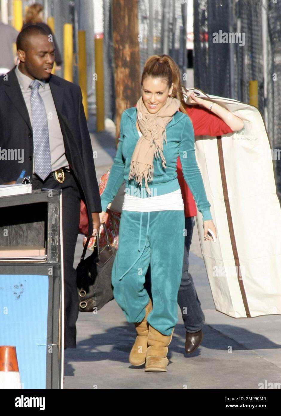 Wearing a blue-green track suit and a tan scarf along with a pair of ...