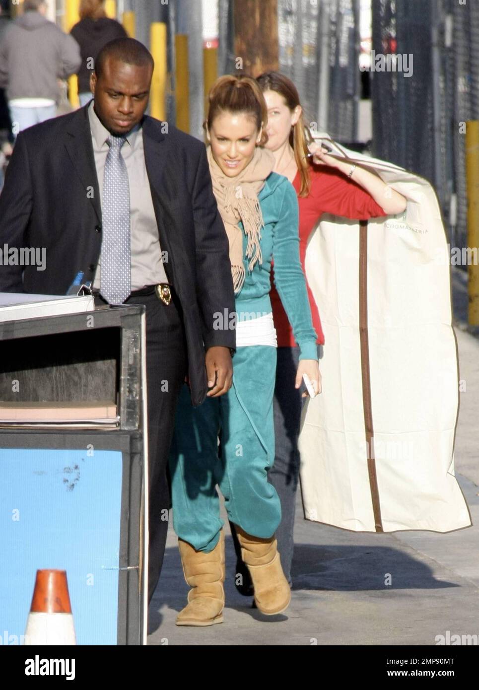 Wearing a blue-green track suit and a tan scarf along with a pair of ...