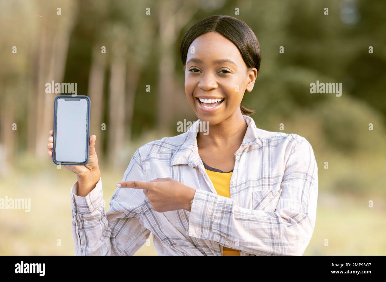 Mockup phone screen, smile and portrait black woman pointing at marketing or advertising content ...