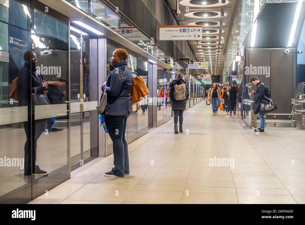 People stand and wait for an Elizabeth Line London Underground train at ...