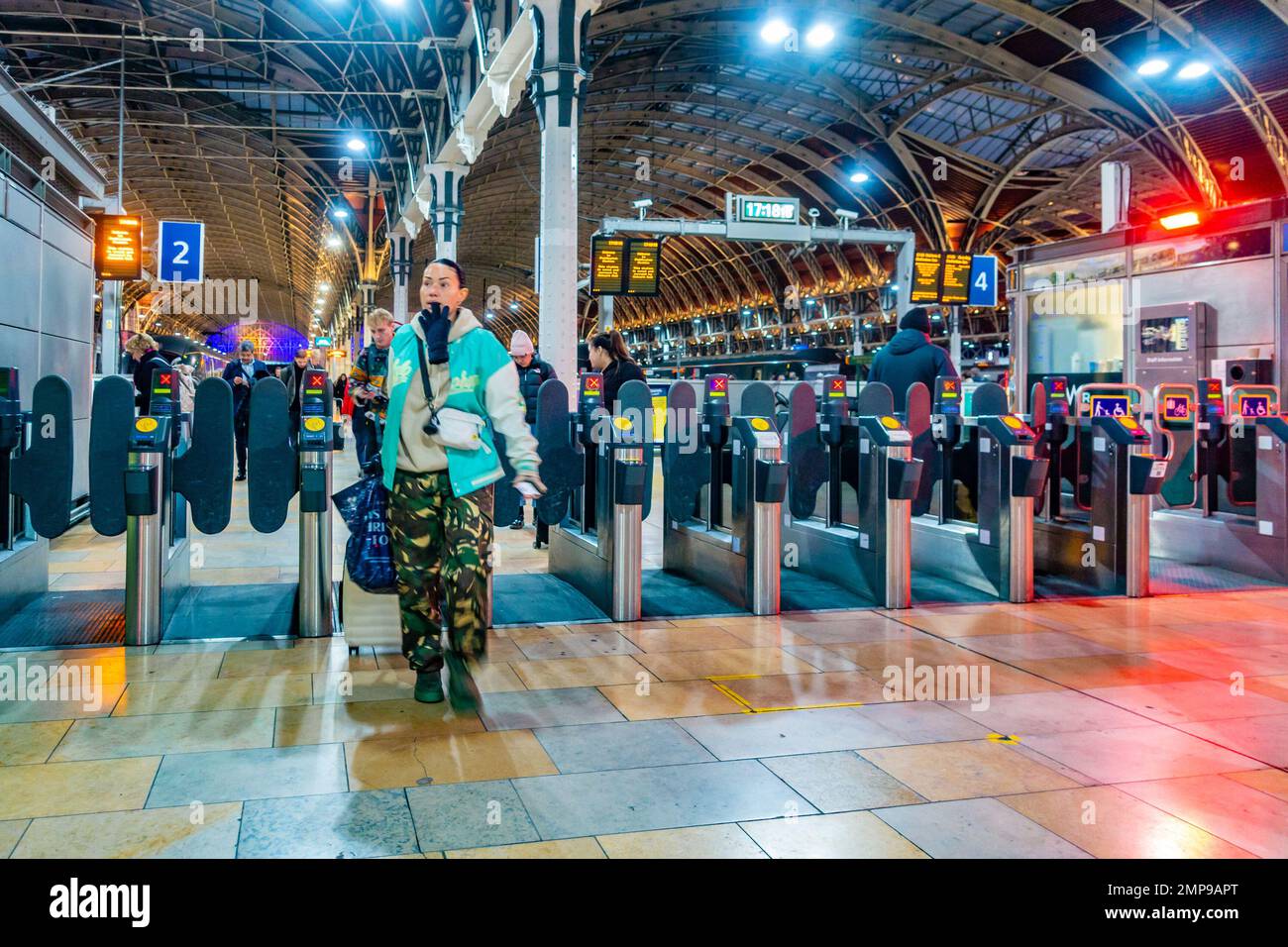 People pass through ticket barriers at Paddington Railway Station in ...