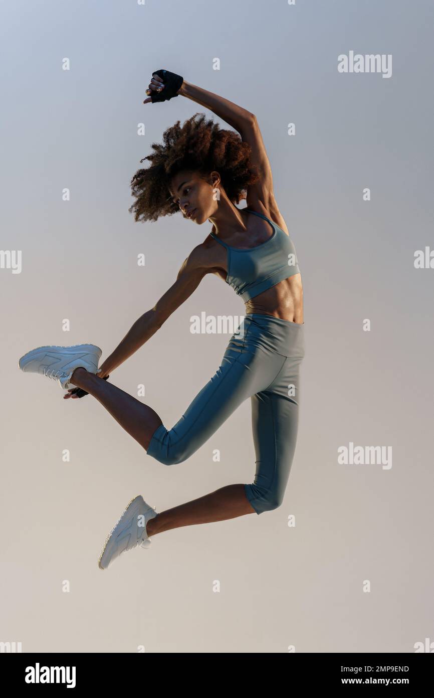 Active sporty woman in sportswear jumping on studio background. Sport ...
