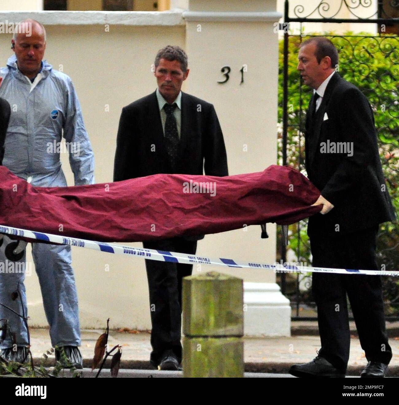 What looks to be the body of Amy Winehouse is carried from her home to ...
