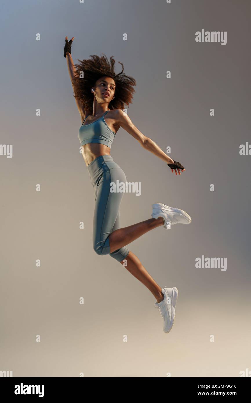 Active sporty woman in sportswear jumping on studio background. Sport ...