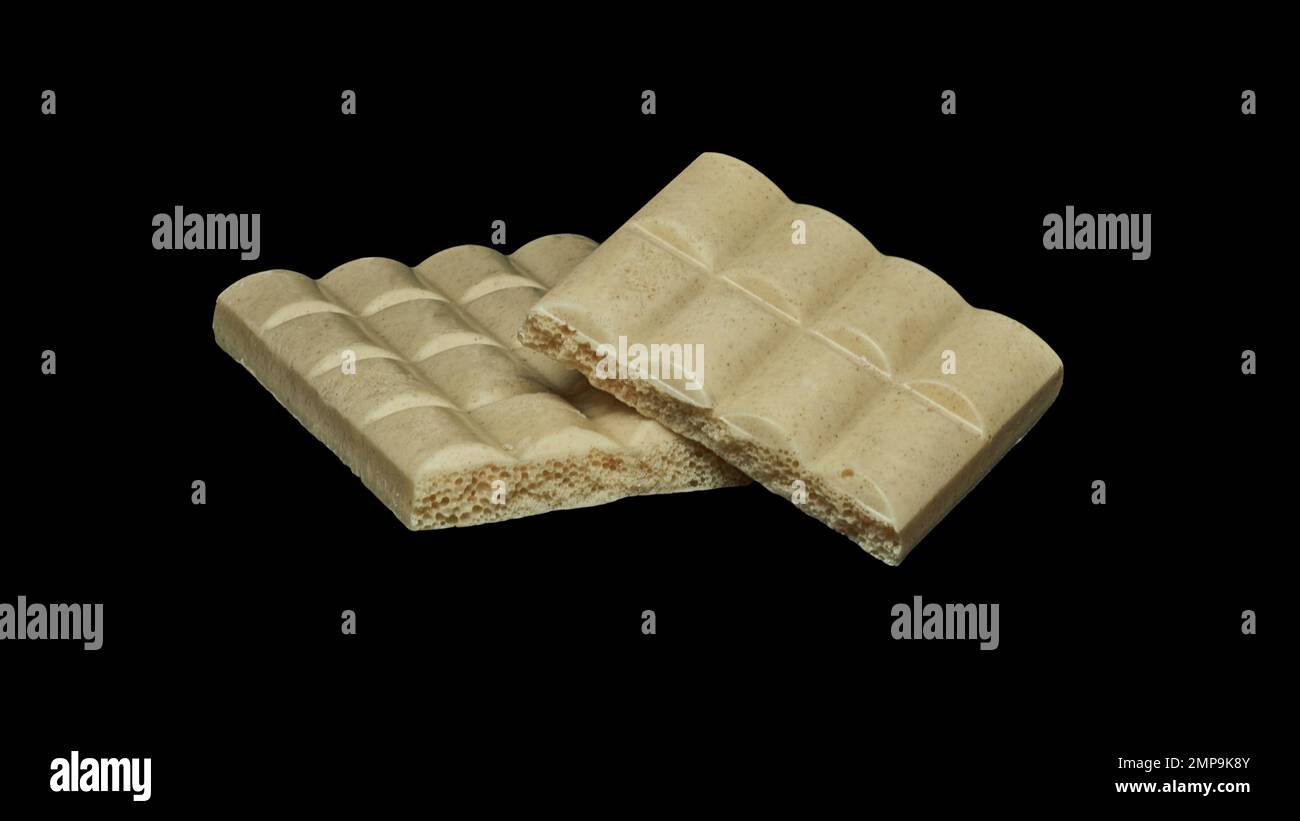 Image of a broken bar of white chocolate on a black background Stock ...