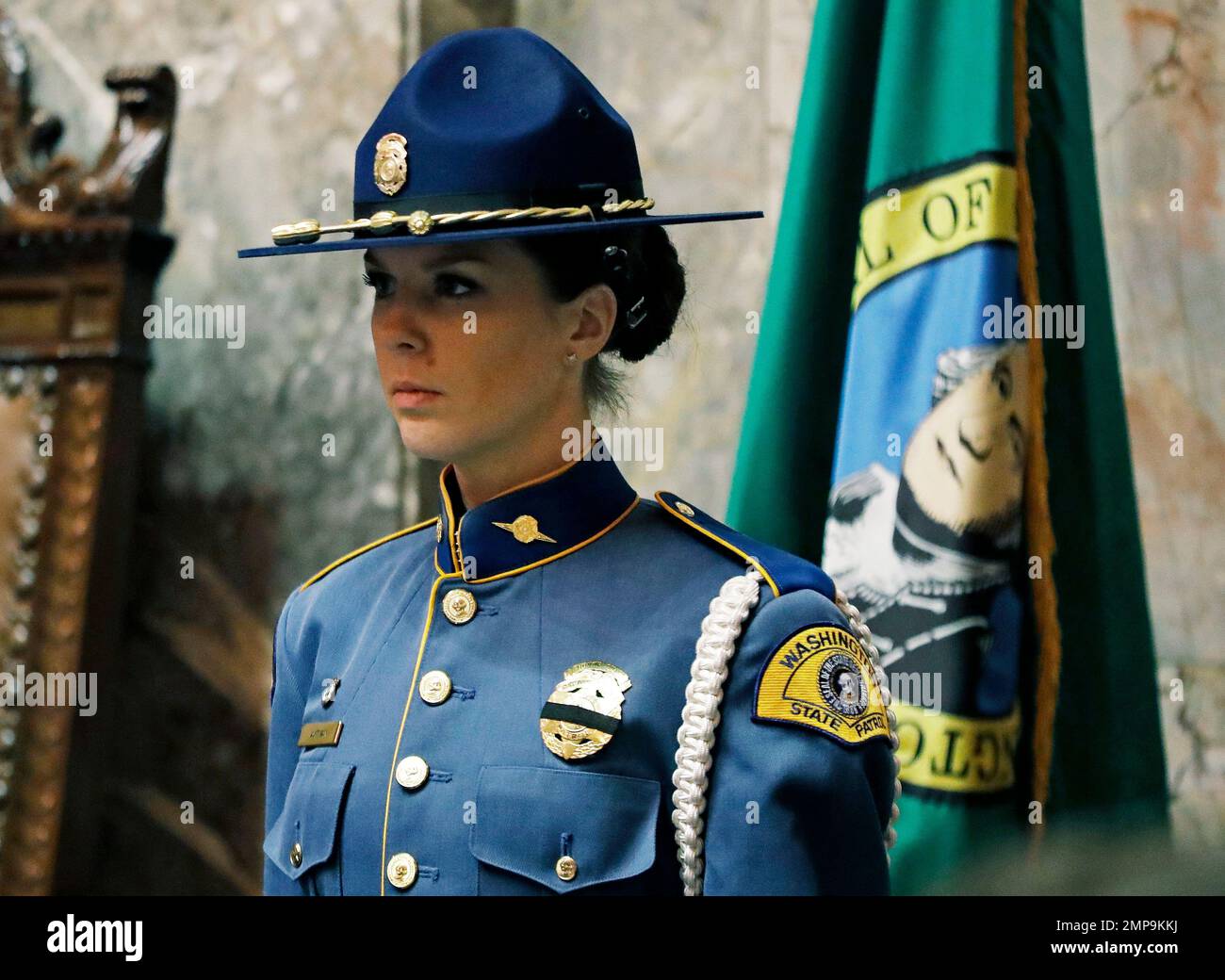 A Washington State Patrol trooper wears a black band across her badge ...