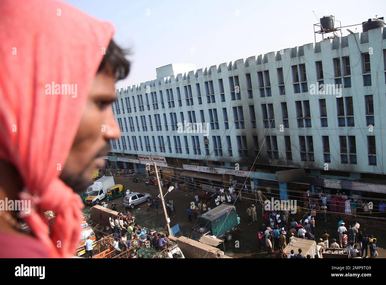 An Indian laborer watches police secure the area outside the burnt ...