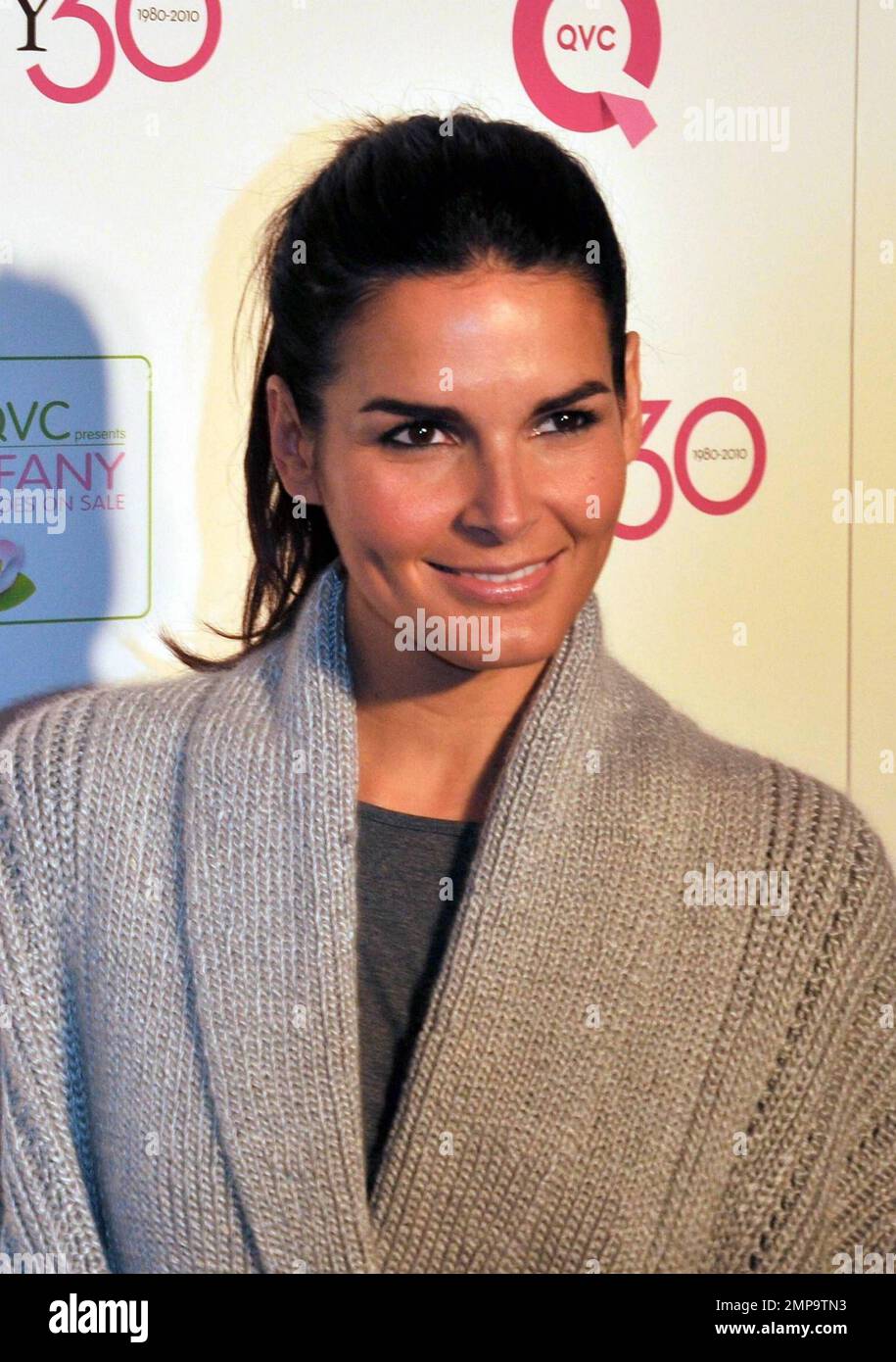 Actress Angie Harmon wears a grey sweater cinched with a black belt as ...