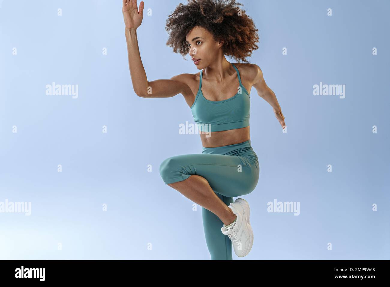 Close up of sporty woman running in Mid-Air exercising during cardio ...
