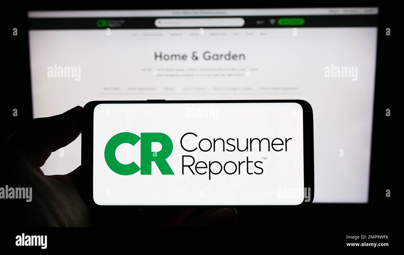 Person holding cellphone with logo of US organization Consumer Reports ...