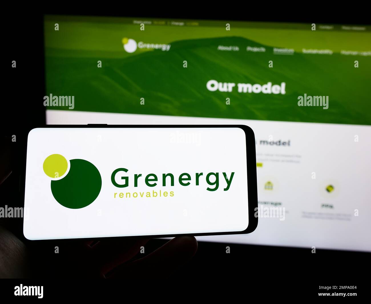 Person holding mobile phone with logo of energy company Grenergy ...