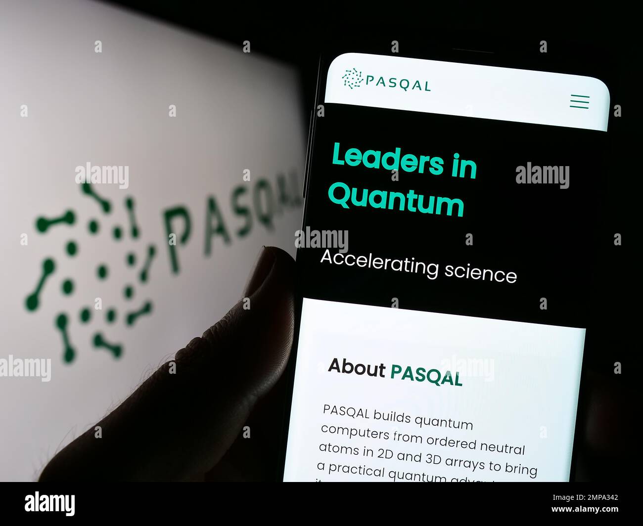 Person holding smartphone with webpage of French quantum processing company PASQAL SAS on screen ...