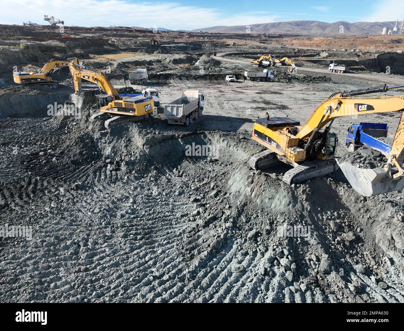 Excavators working together on huge mining site, Caterpillar excavators Stock Photo - Alamy