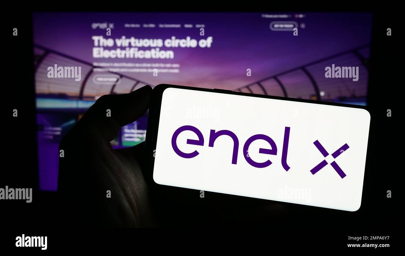Person holding mobile phone with logo of Italian energy company Enel X ...