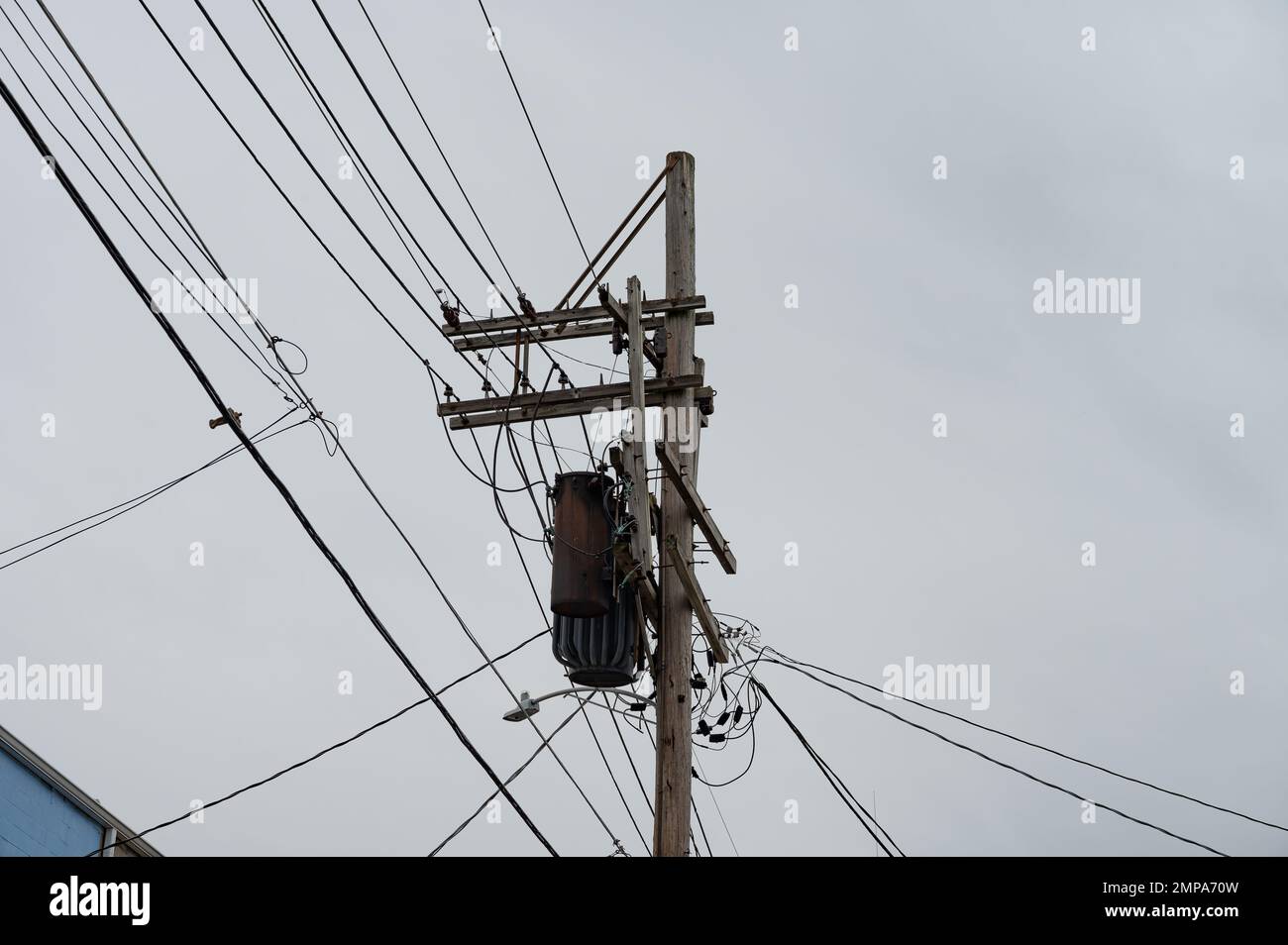 A close-up shot of an old wooden electric pole with wires, capacitor ...